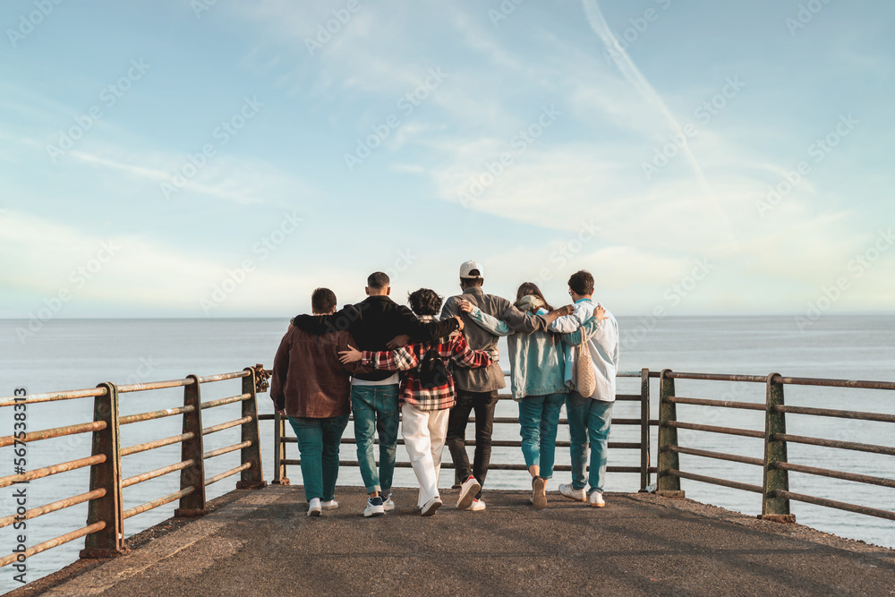 A diverse group of young friends come together in a tight embrace ...