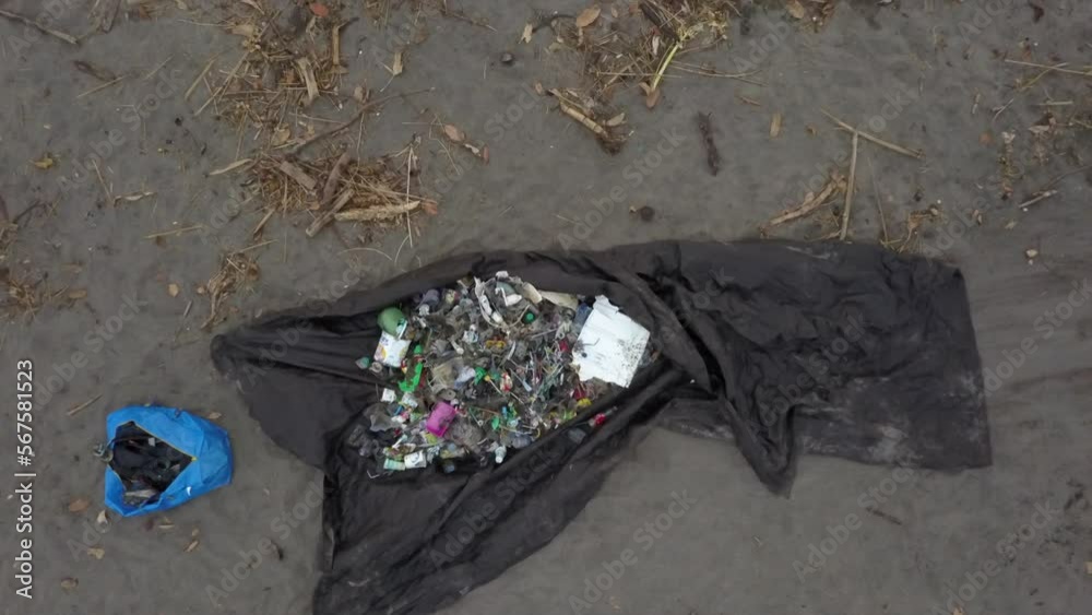 Aerial rises from tarp of trash during beach clean up event in Bali ...
