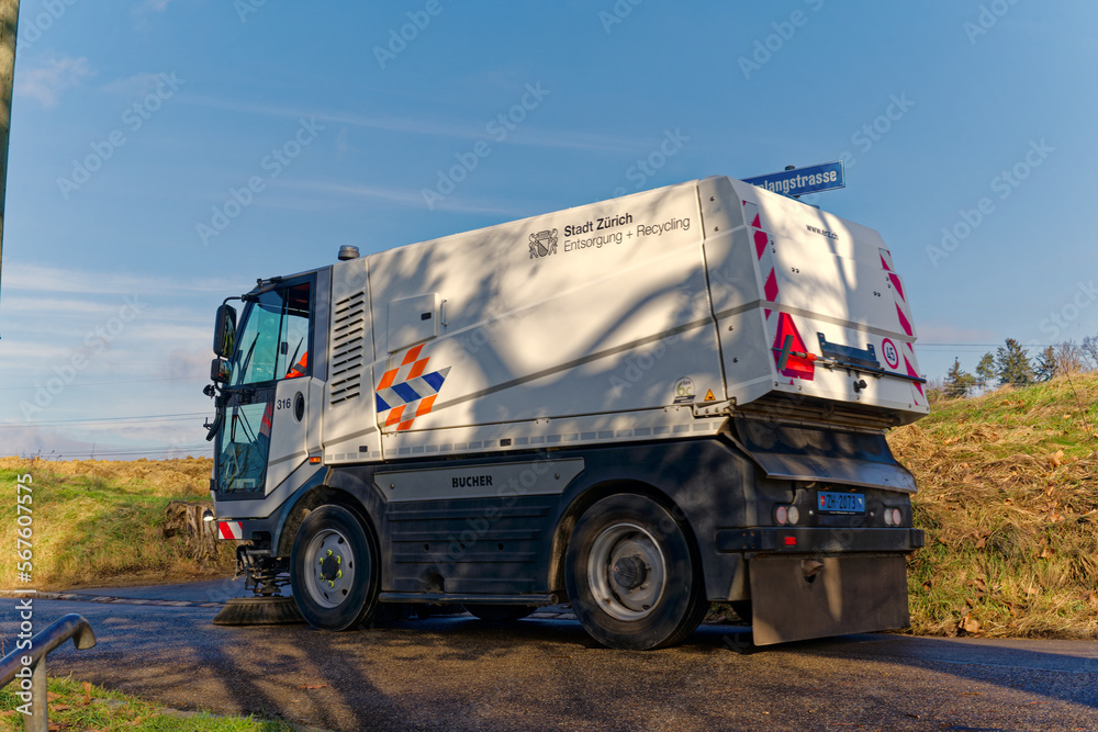 White cleaning vehicle of city services with two workers turning at ...