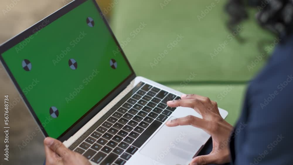 A black woman works at a computer. The laptop is on your lap. Close-up ...