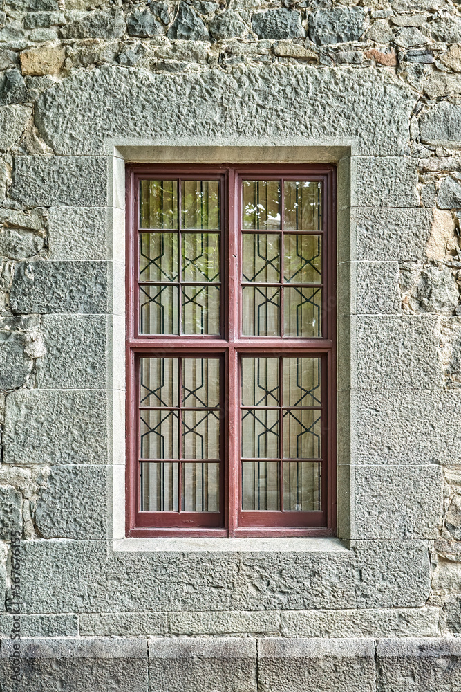 Old windows with wrought iron grating on stone wall of historical ...