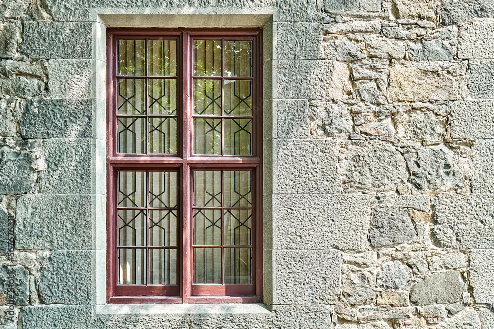 Old windows with wrought iron grating on stone wall of historical ...