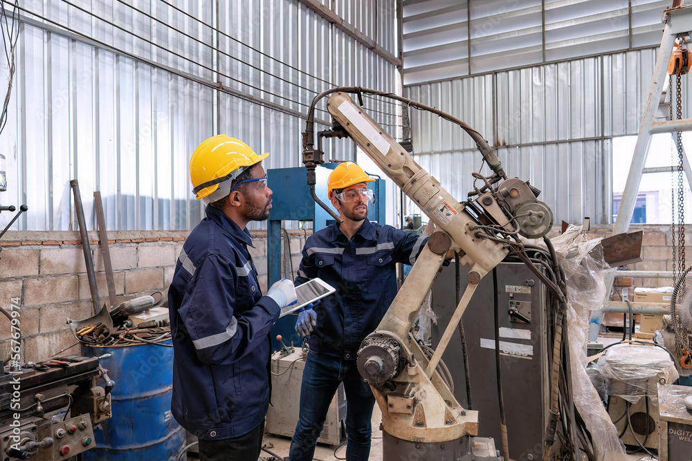 Factory maintenance engineer working with old defected robotic arm in ...