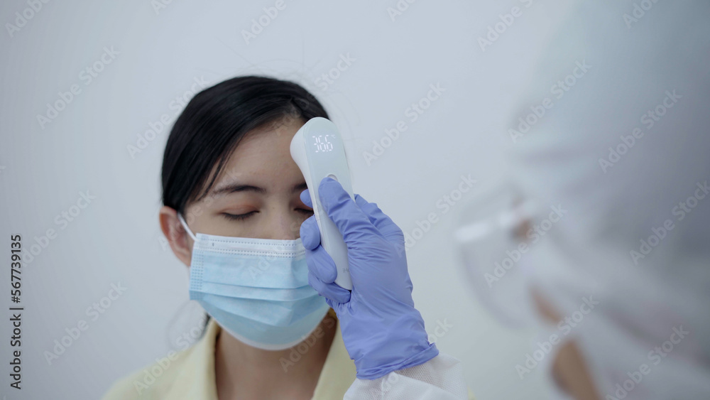 Young doctor using infrared thermometer checking body temperature of ...