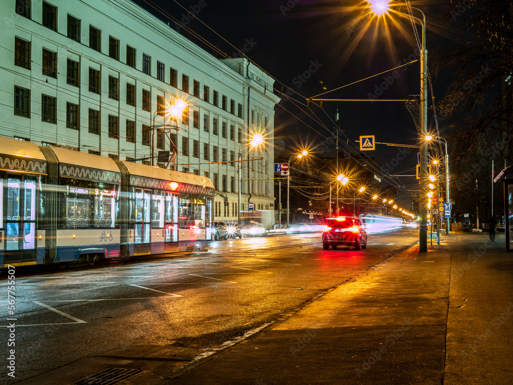 Foto de long exposure tram in a blurry form in the night city center ...