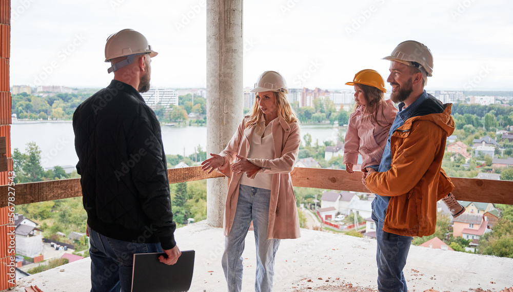 Man and woman with child standing inside apartment building under ...