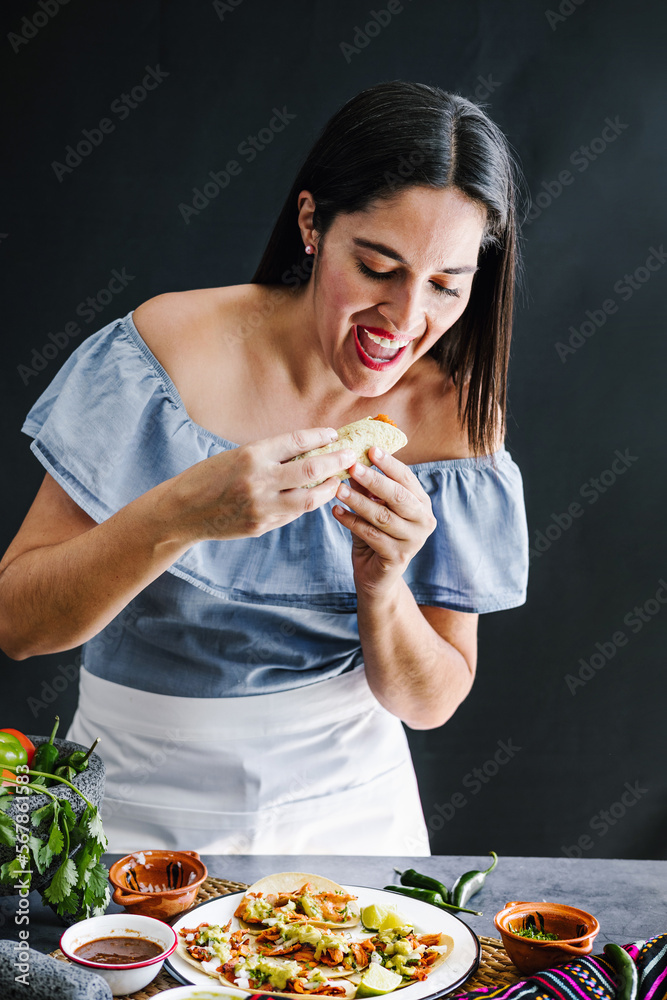 Mexican woman preparing tacos al pastor and eating mexican food in ...