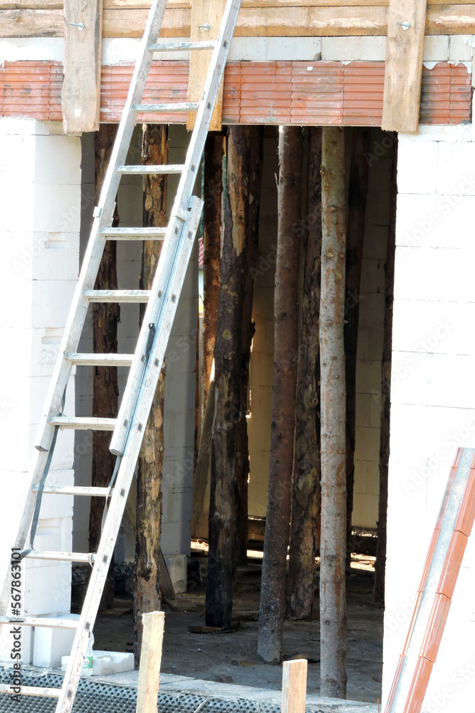 A ladder leaning against a wall, a rough window opening, reinforced ...