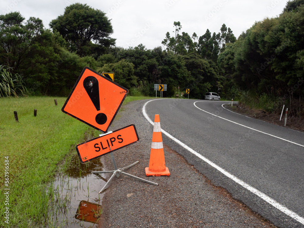 A roadside sign says slips a warning that landslides may be ahead ...