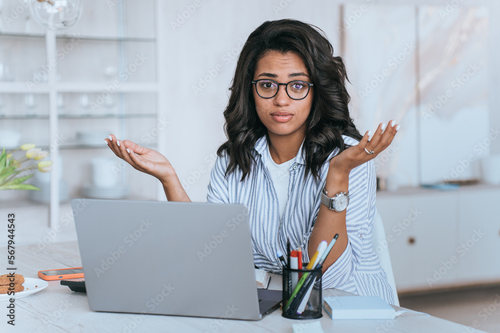 Foto de Frustrated African American young woman remote works home using ...