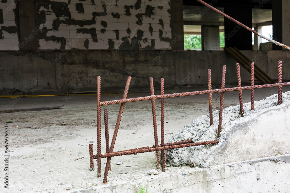 Rusty bars of reinforcement stick out of the wall of the unfinished ...