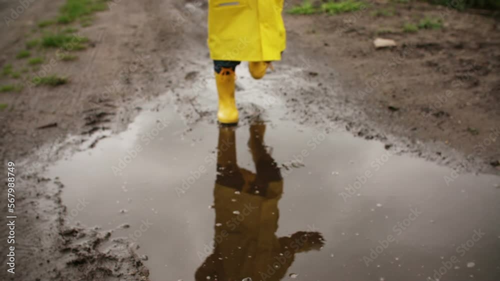 Young boy running through puddle after rain Stock Video | Adobe Stock