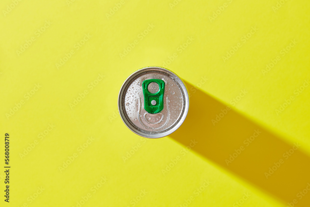 can with green pull tab, water drops, condensate on yellow background ...