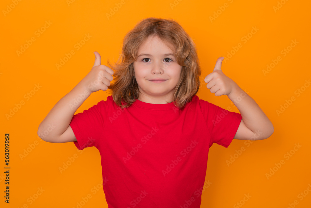 Child showing thumbs up on studio isolated background. Kid boy making ...