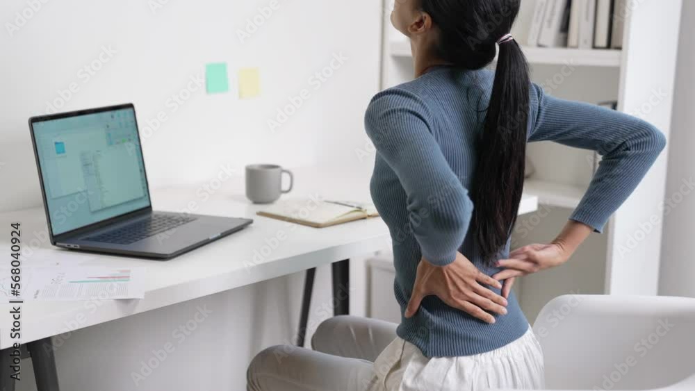 Young Asian business woman suffering from back pain while working ...