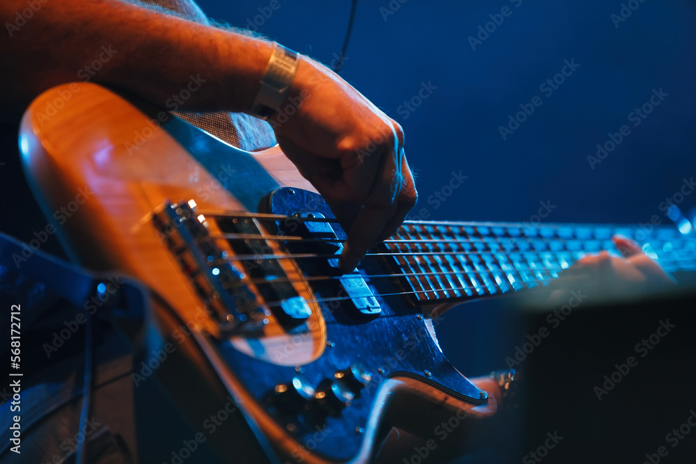 Bass guitar player performing on concert. Close up photo of ...