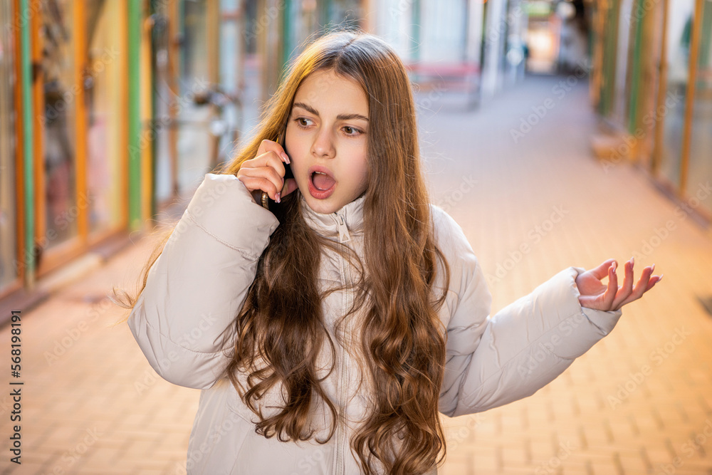 shocked teen girl having phone call in the street. teen girl having ...