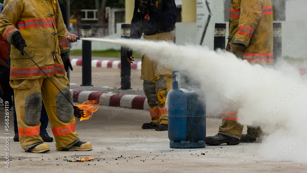 Showing how to use a fire extinguisher on a training fire for employees ...