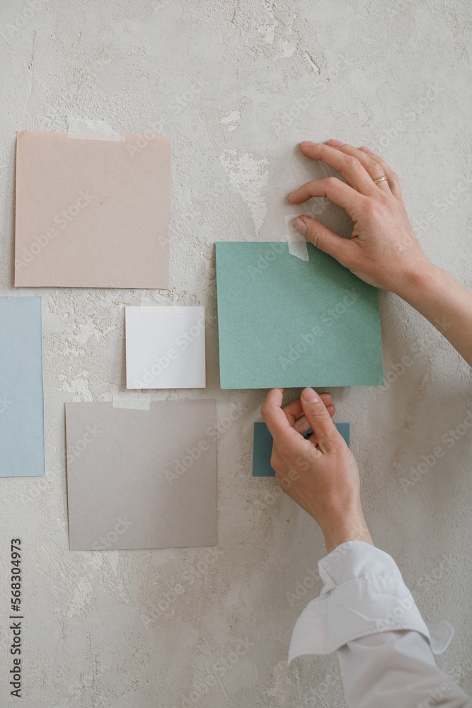Woman taping colour paper card mockups to a wall. Mood board ideas ...