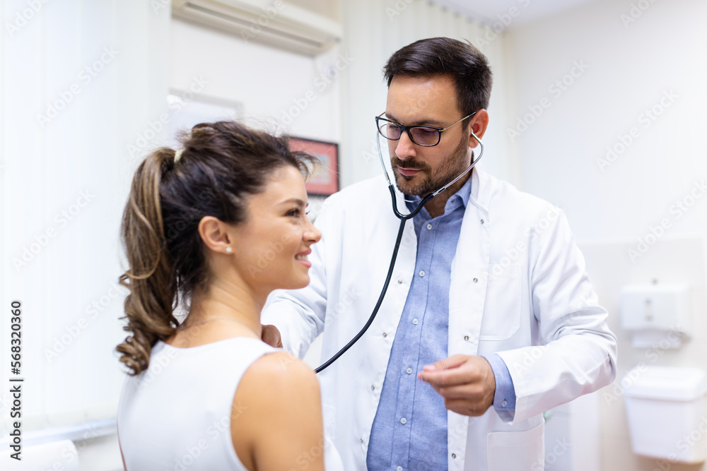Foto de Young doctor is using a stethoscope listen to the heartbeat of ...