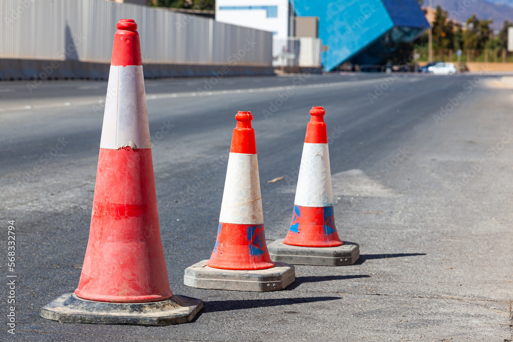 Traffic cones stand in a row on an asphalt road. Devices for temporary ...