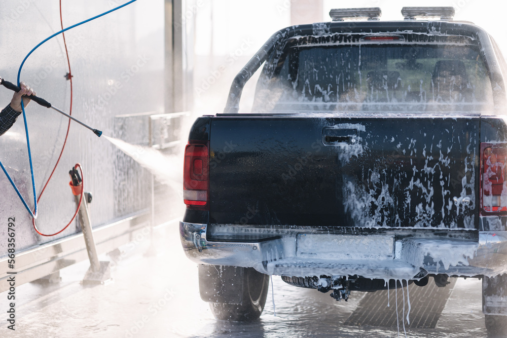 Foto de Process of man washing his car in a self-service car wash ...