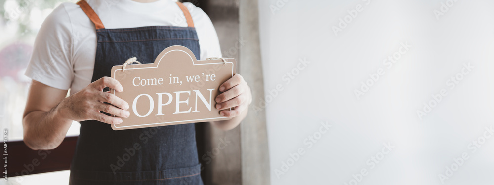Man holding open/close sign in front of entrance, Goods and Service ...