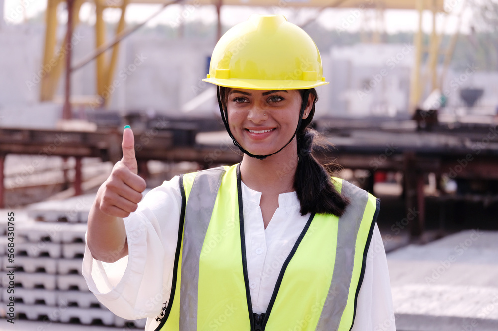 Female worker wearing a safety helmet smiling thumbs up. Stock Photo ...