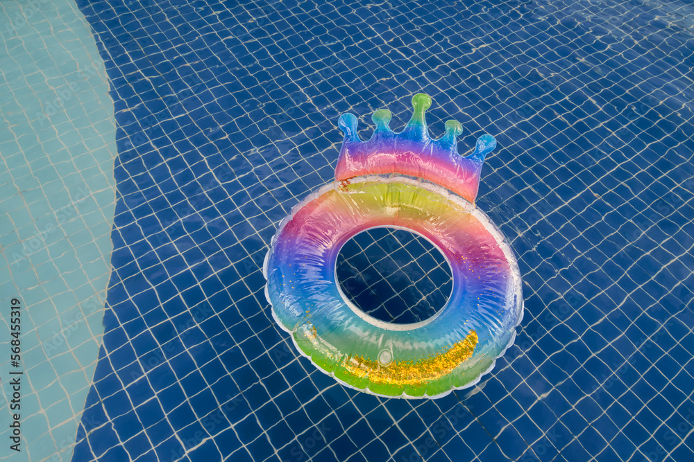 Colorful children's float with golden glitter on top of blue pool water ...