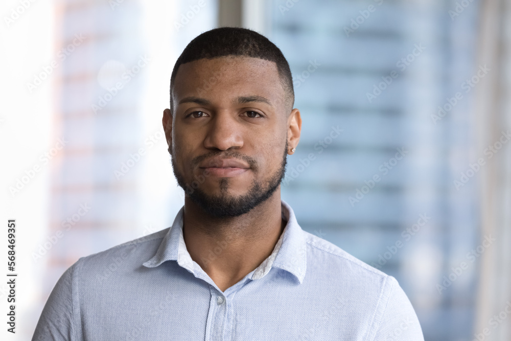 Handsome young African man head shot portrait against blurred big ...