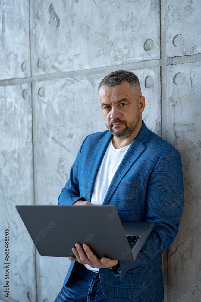 Bearded young confident guy stand behind office desk with laptop ...