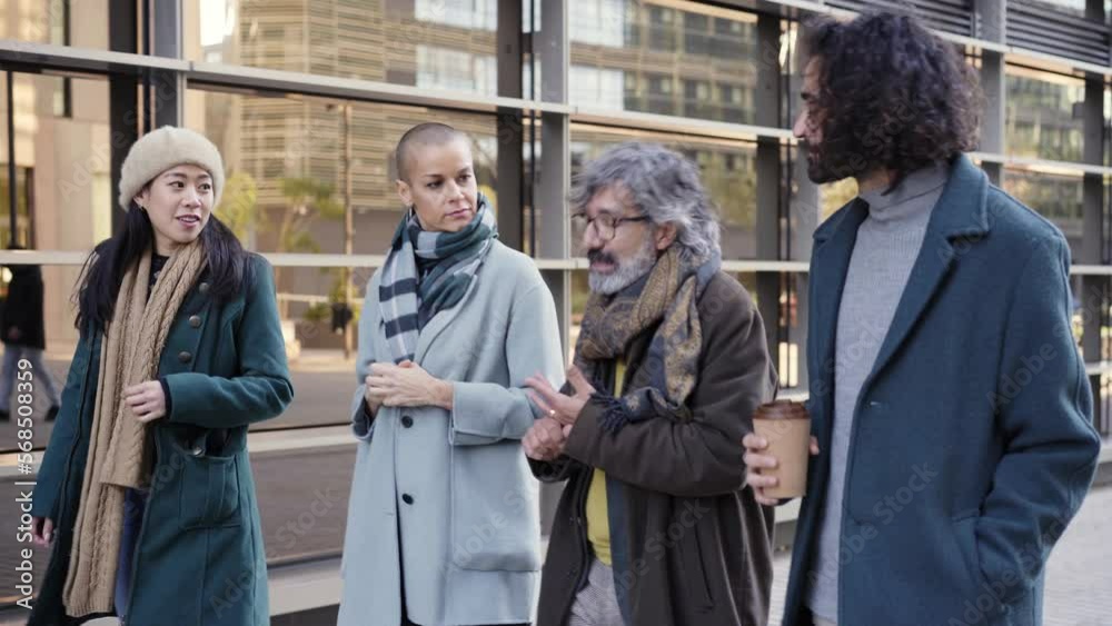 A multi-ethnic group of cheerful business people walking towards ...