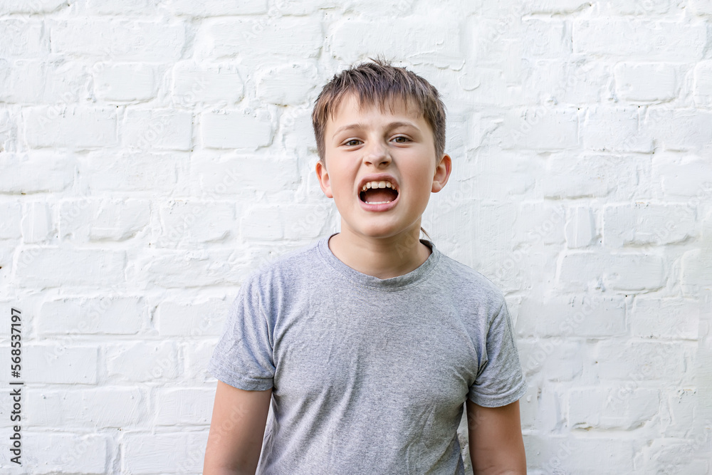 The teenager screams in shock. Portrait of a boy with an open mouth ...