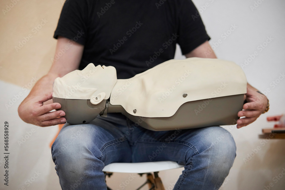 the instructor holds a first aid dummy. Training in first aid and ...