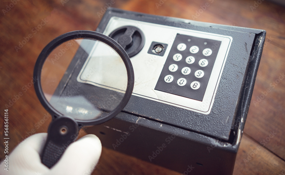 The detective's hand examines the traces of the robbery through a ...