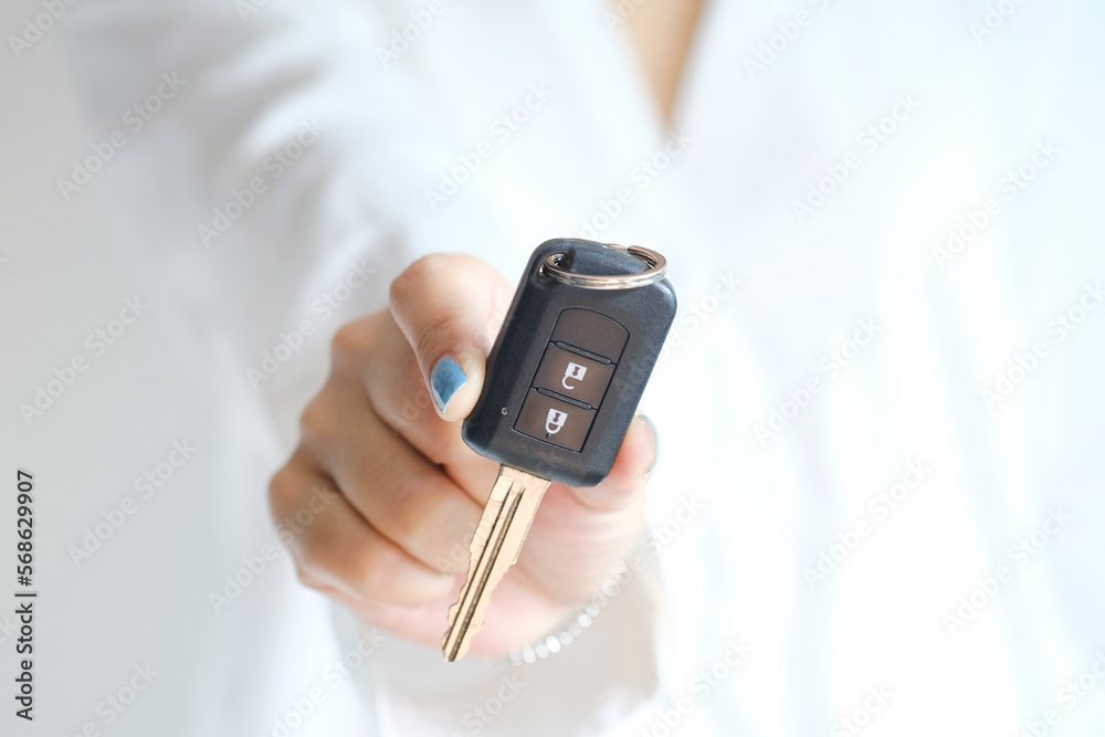 A woman is holding and showing the smart key of the car she handed over ...