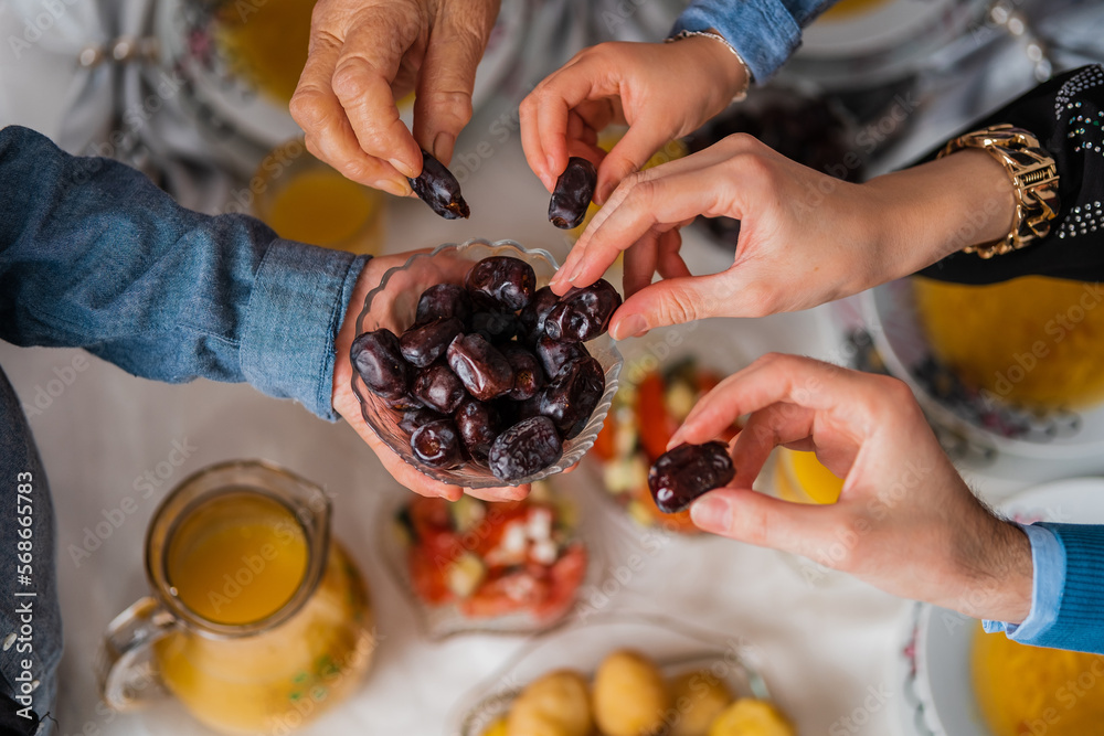 Happy Muslim family having iftar dinner to break fasting during Ramadan ...