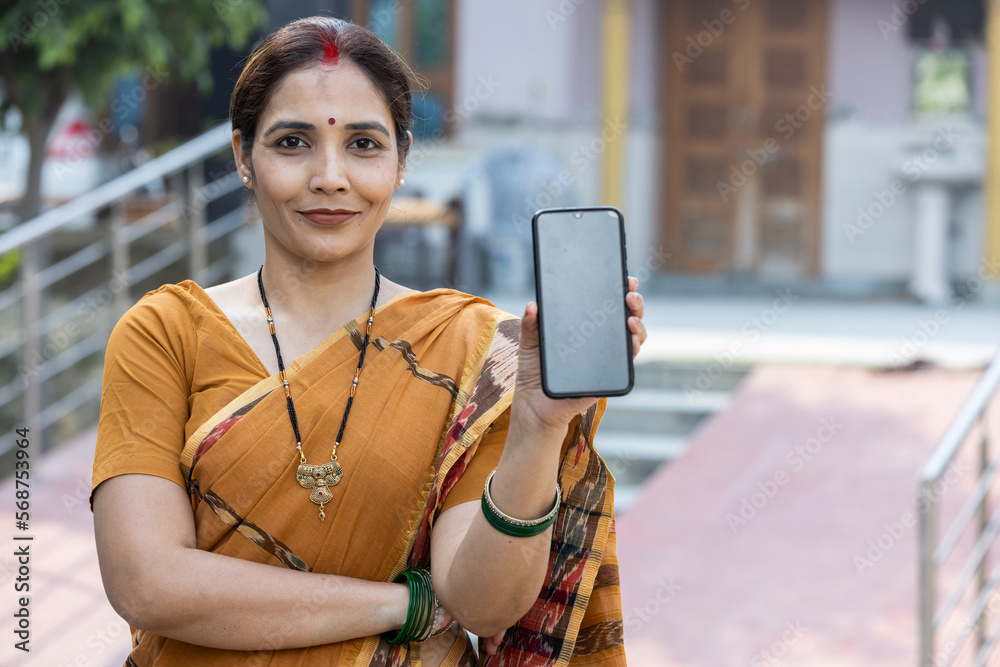 Indian rural woman showing smartphone screen. Stock Photo | Adobe Stock
