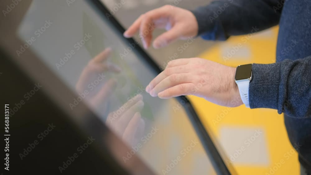 Man using touchscreen terminal in mall. Detail view outstretched male ...