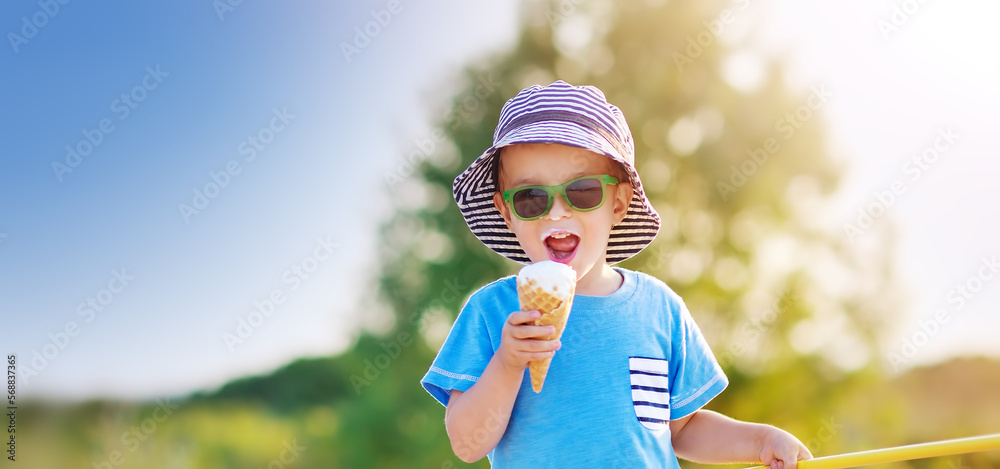 Cute boy eating ice cream in sunny day in nature. Stock Photo | Adobe Stock