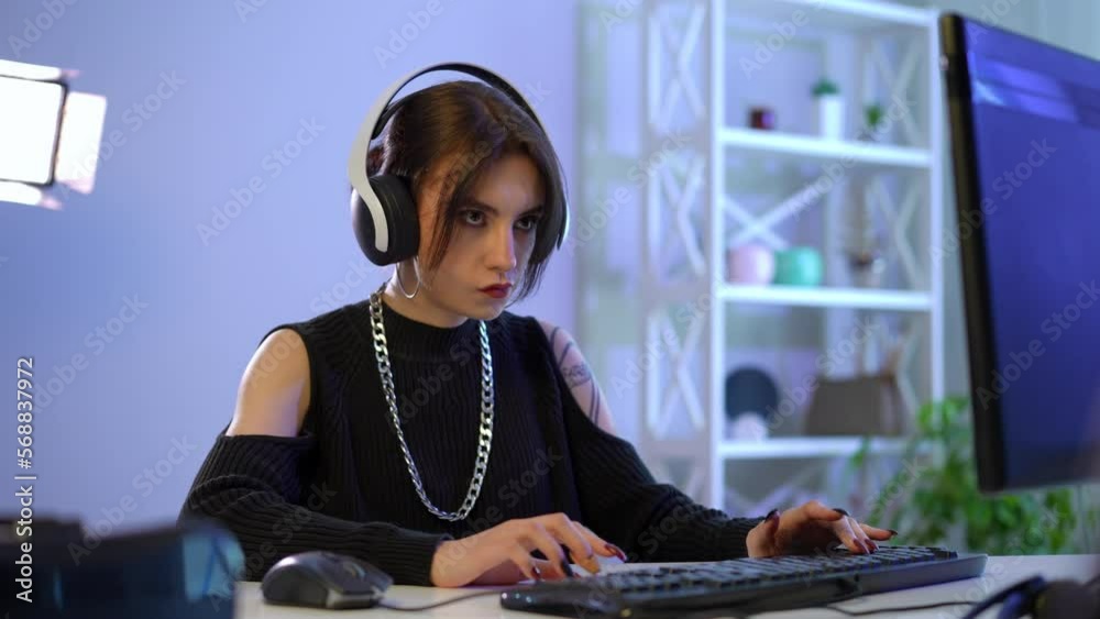 Young beautiful woman with serious facial expression putting on ...