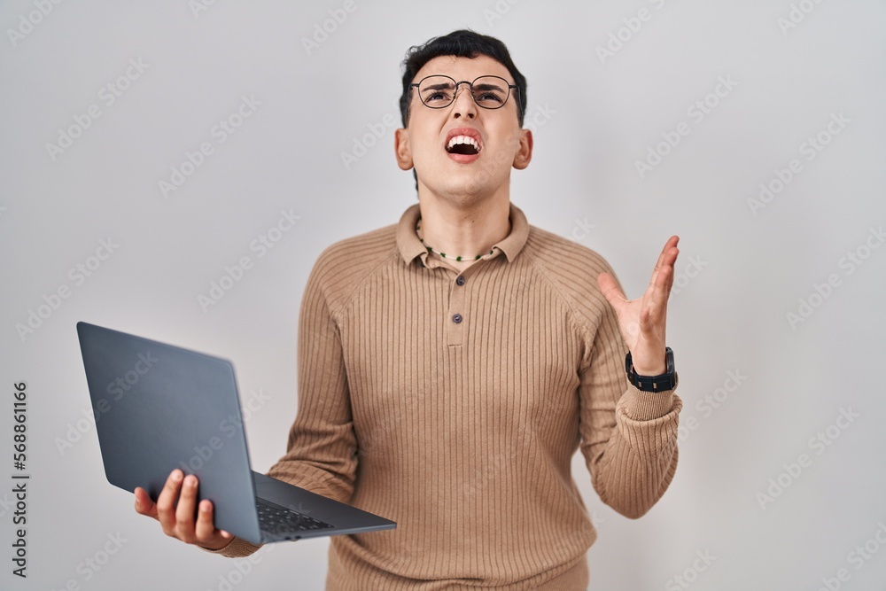 Non binary person using computer laptop crazy and mad shouting and ...