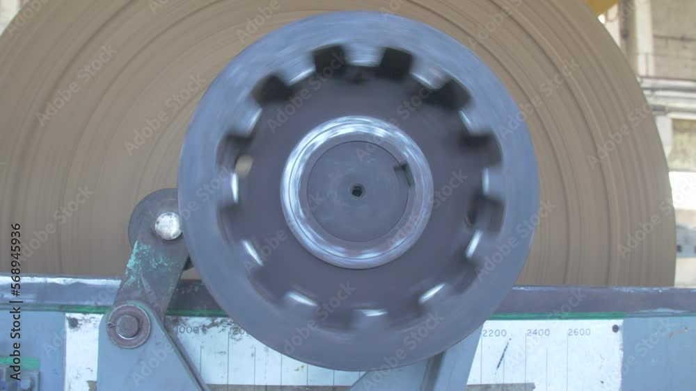 Bobbin of brown paper for making pulp cardboard boxes is spun on an ...