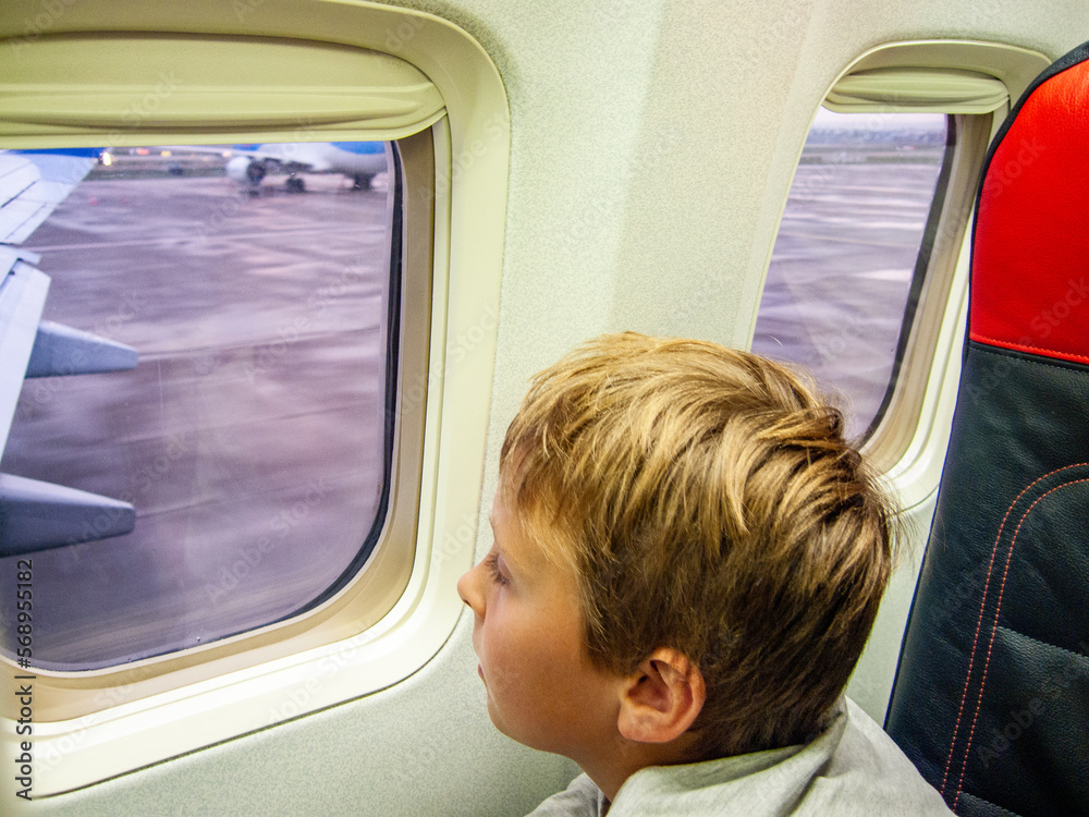child looks out the window of the plane on the runway Stock Photo ...