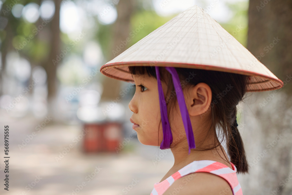 Little Asian girl wearing a Vietnamese straw hat under a big tree Stock ...