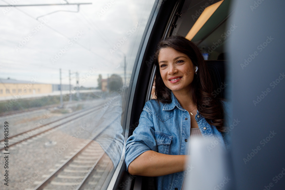 Smiling thoughtful commuter looking through window from train Stock ...