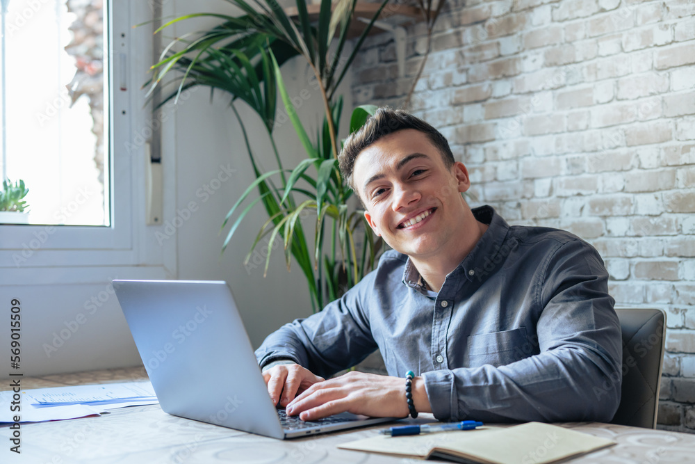 Good-looking millennial office employee in glasses sitting at desk in ...