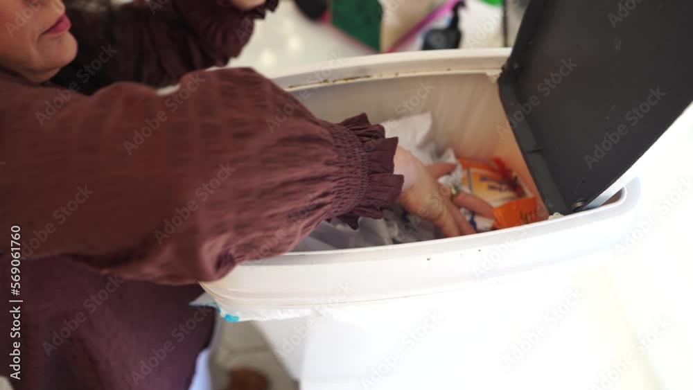 Throwing rubbish in the bin. Putting rubbish in an inside bin in ...