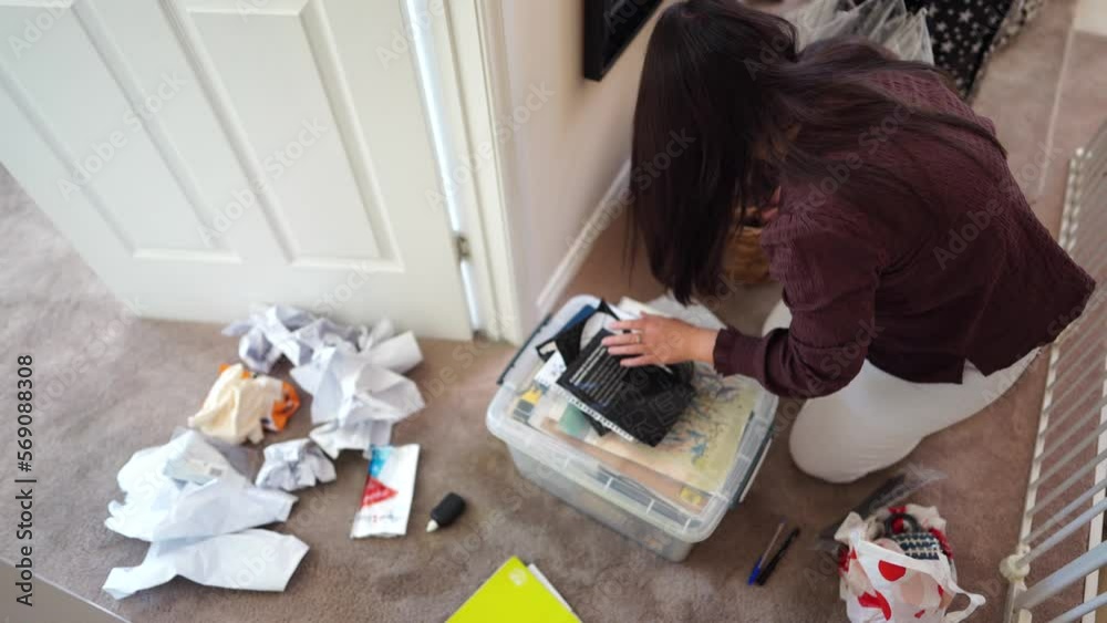 Girl sorting household items and storing personal items in plastic ...