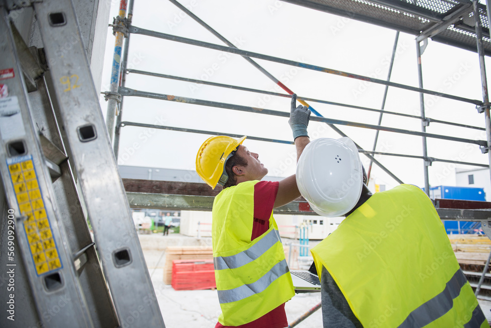 Construction workers looking up at building site Stock Photo | Adobe Stock